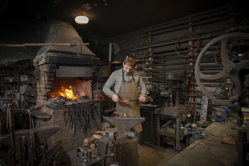 The Blacksmith Manually Forging the Red-hot Metal on the Anvil in ...