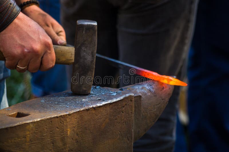 Blacksmith Performs the Forging of Hot Glowing Metal on the Anvil Stock ...