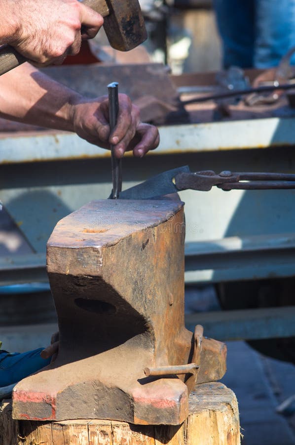 Blacksmith Performs the Forging of Hot Glowing Metal on the Anvil Stock ...
