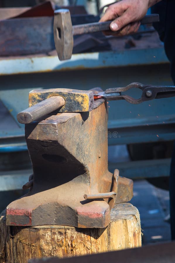 Blacksmith Performs the Forging of Hot Glowing Metal on the Anvil Stock ...