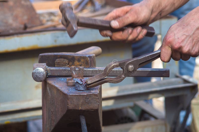 Blacksmith Performs the Forging of Hot Glowing Metal on the Anvil Stock ...