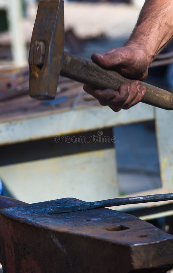 Blacksmith Performs the Forging of Hot Glowing Metal on the Anvil Stock ...