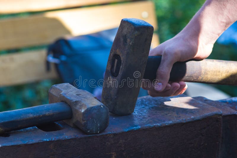 Blacksmith Performs the Forging of Hot Glowing Metal on the Anvil Stock ...