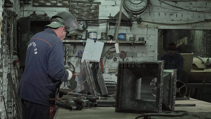 Blacksmith in Protective Clothing and Helmet Soldering Wrought-iron ...