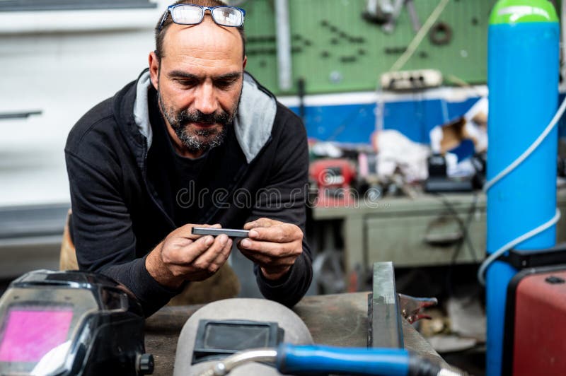Performing a Weld: the Man in the Welding Mask is Positioned with the ...