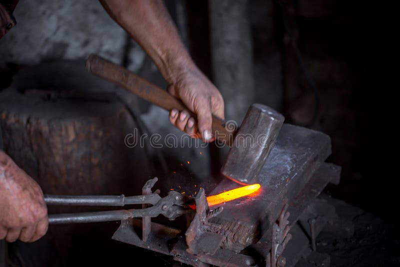 Blacksmith`s Hands at Work. in One Hand a Hammer, in the Other a ...