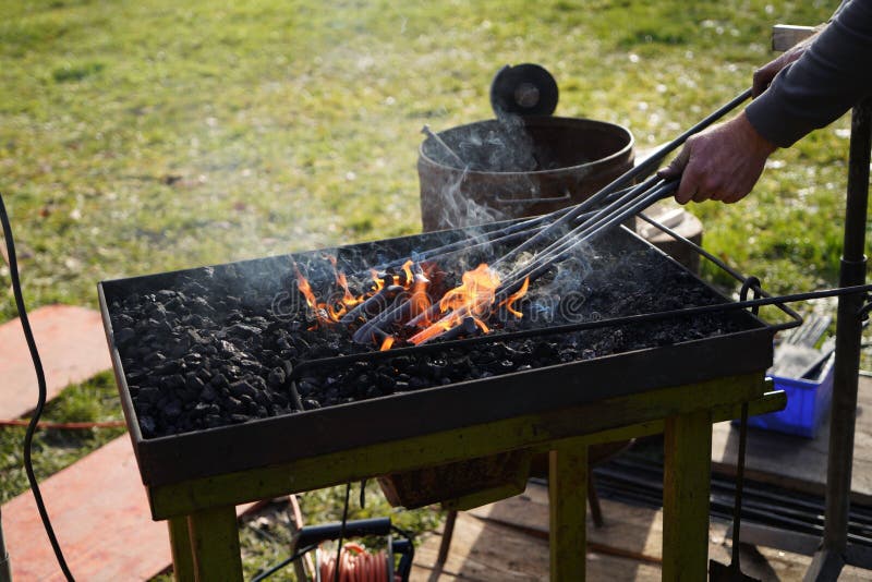 Blacksmith Shaping a Piece of Iron, Warming it on the Fired Coal ...