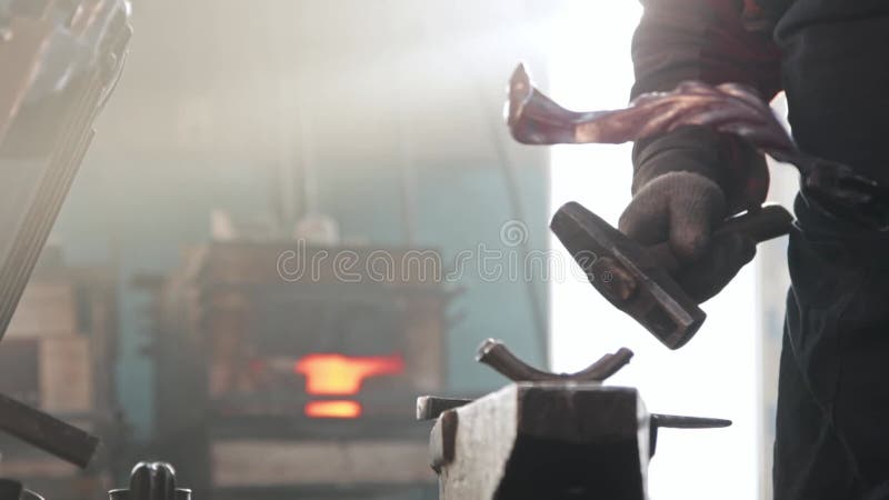 Blacksmith Shaping a Thin Piece of Metal Using a Form, Anvil and Hammer ...