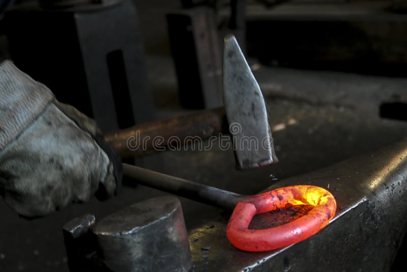 A Blacksmith at Work with Glowing Irons. Hot Iron Forge, a Black Stock ...