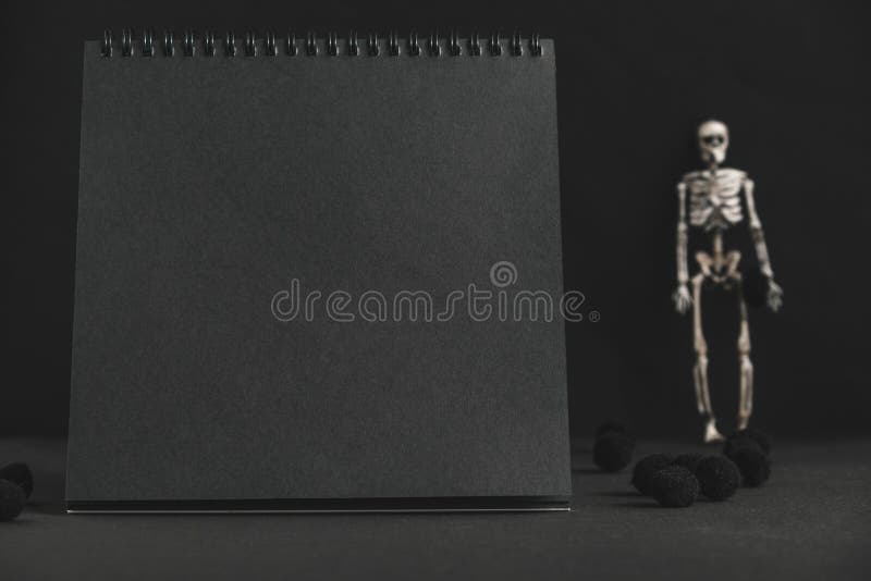 Blank Black Notebook on a Black Background with a Blurred Skeleton and ...