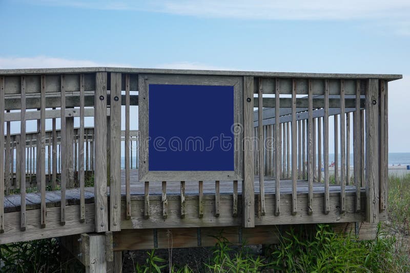 A Blank Blue Sign on the Side of the Fence on a Wooden Boardwalk Stock ...