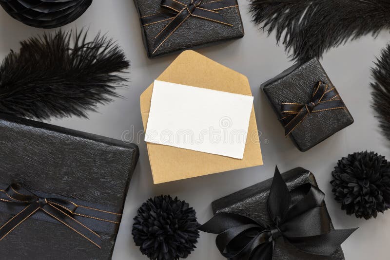 Blank Card and Envelope between Wrapped Gift Boxes and Black Feathers ...