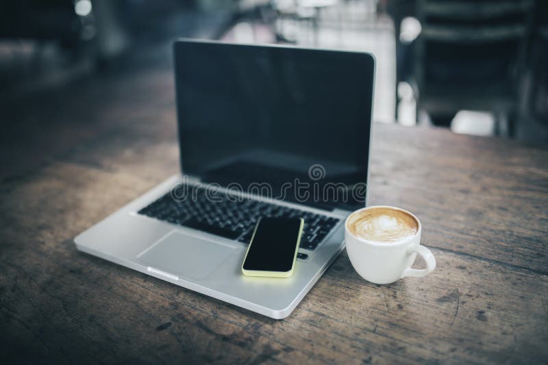 Blank Cell Phone on Laptop and Coffee Mug on Wooden Table Stock Photo ...