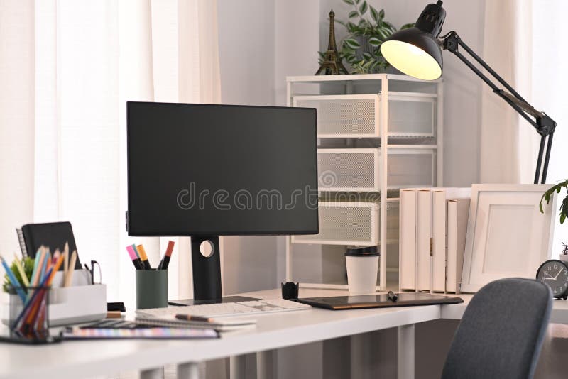A Blank Computer Screen, Stationery and Lamp on White Table in Modern ...