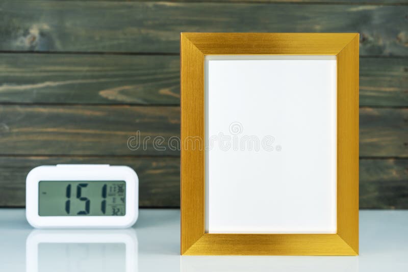 Blank Golden Frame and Digital Alarm Clock on Table Stock Image - Image ...