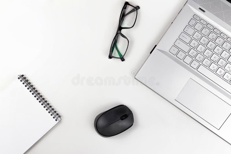 A Blank Notebook with Glasses a Computer Mouse and a Laptop are on a ...