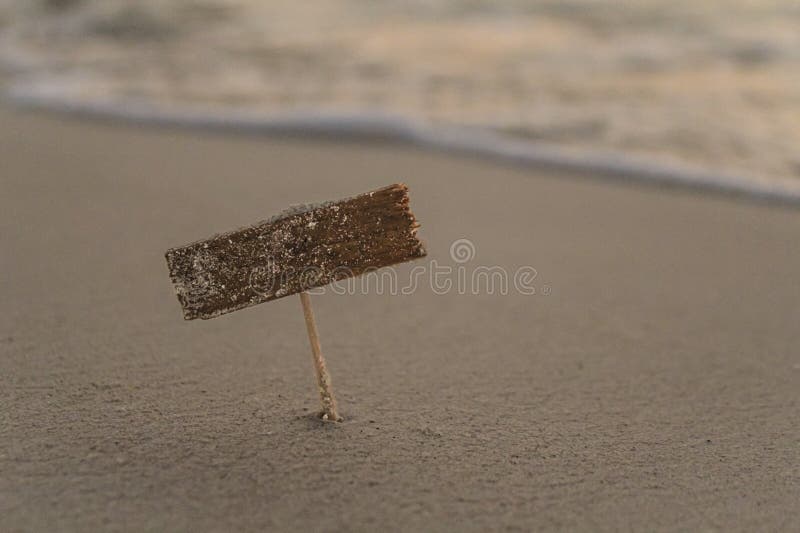 A Blank Rectangular Wooden Sign Slightly Covered with Sand on the Beach ...