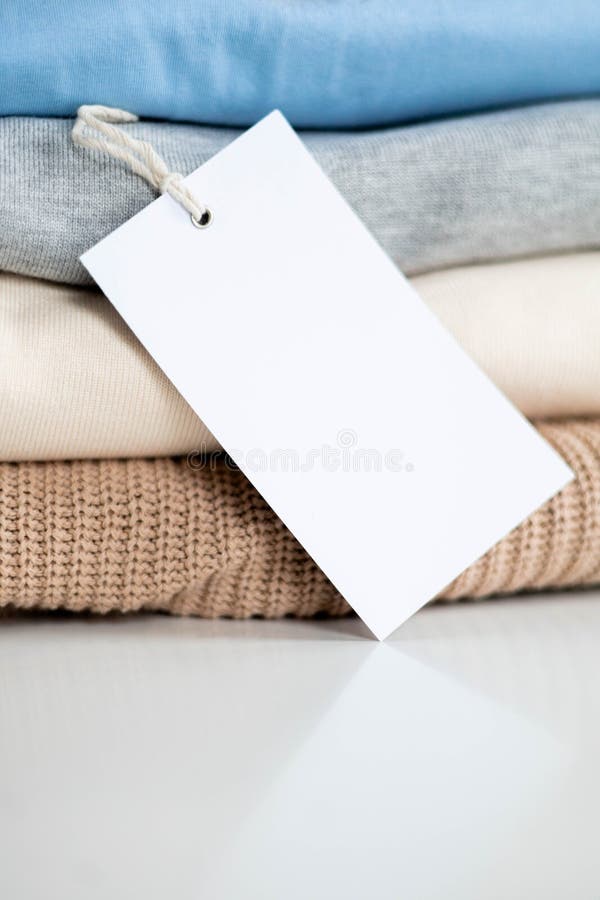 Blank White Label Hanging on Stack of Natural Cotton Jersey Clothes in ...