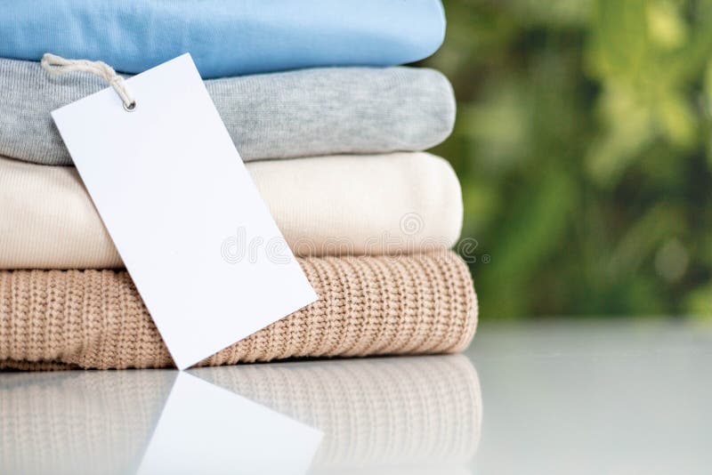Blank White Label Hanging on Stack of Natural Cotton Jersey Clothes in ...