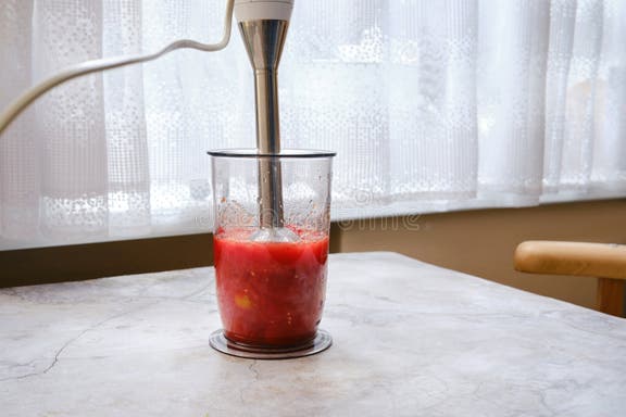 Blending Fresh Tomatoes in a Clear Glass Container Using an Immersion ...