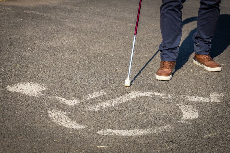 Blind Person with a Cane Walking in Front of a Horizontal Sign for ...