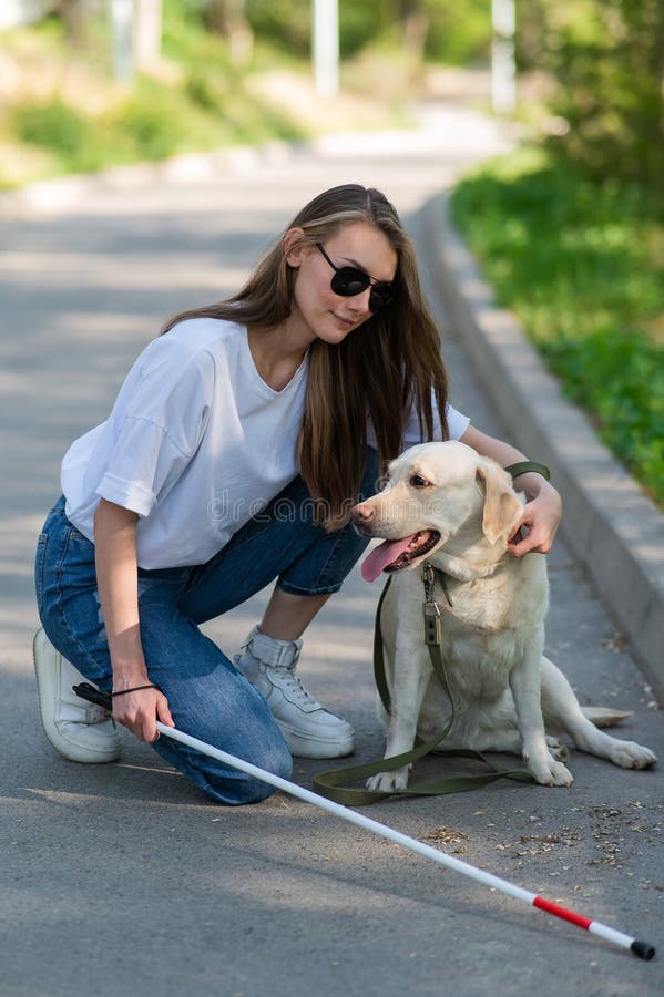 Blind Young Woman Cuddling with Guide Dog on a Walk Outdoors. Stock ...