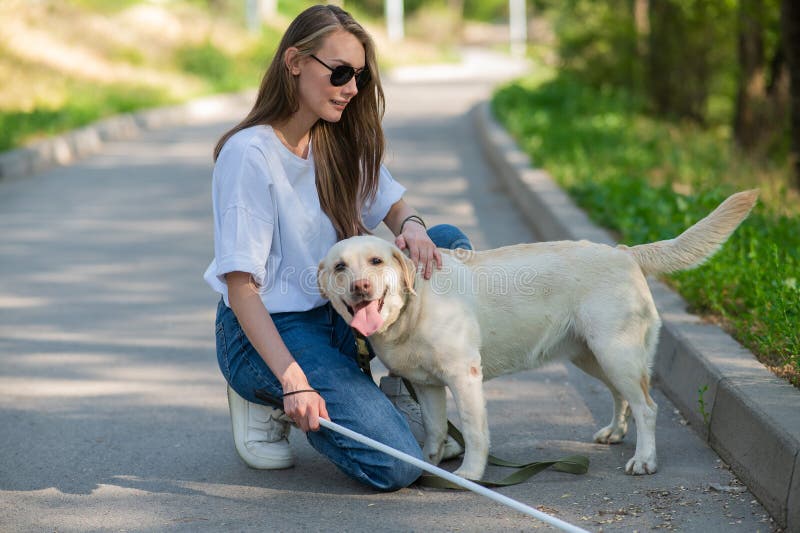 Blind Young Woman Cuddling with Guide Dog on a Walk Outdoors. Stock ...