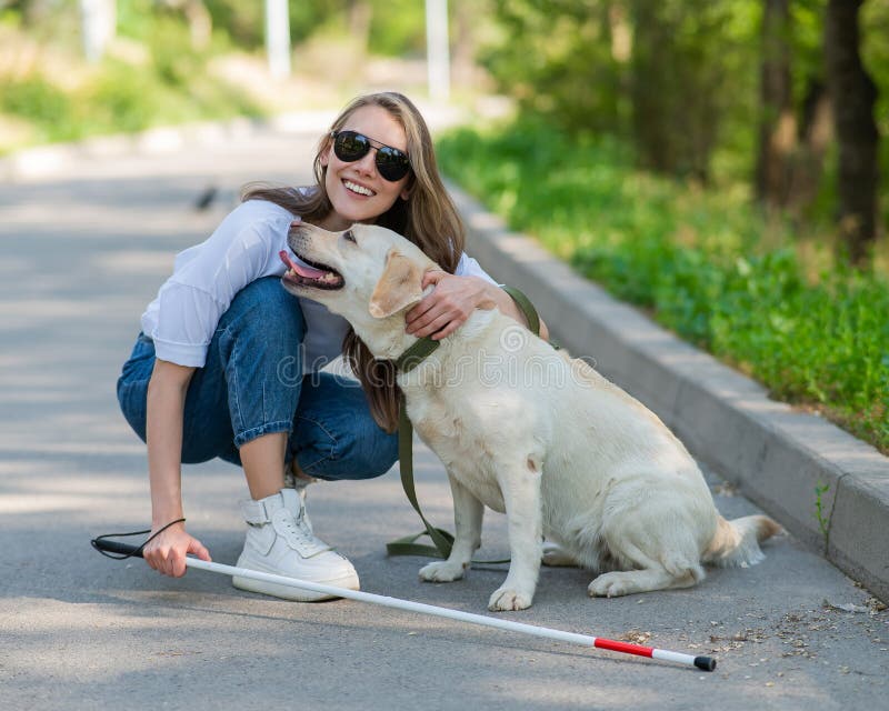 Blind Young Woman Cuddling with Guide Dog on a Walk Outdoors. Stock ...