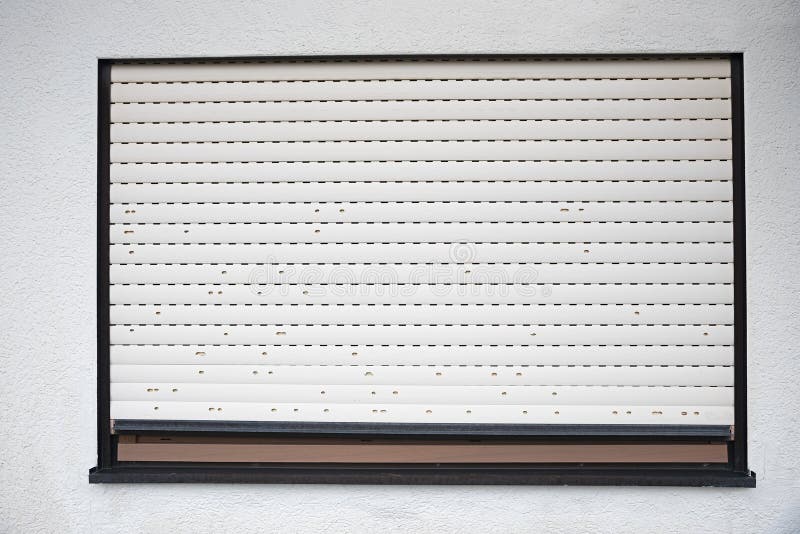 Blinds on the Window Damaged by Hail. Broken Roller Shutter with Holes ...