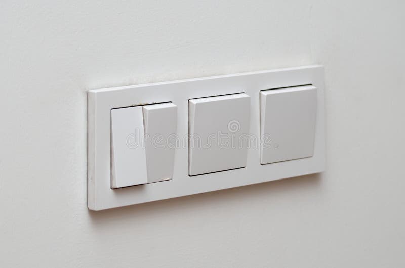 Block of Three White Plastic Electrical Switches on a White Wall Stock ...