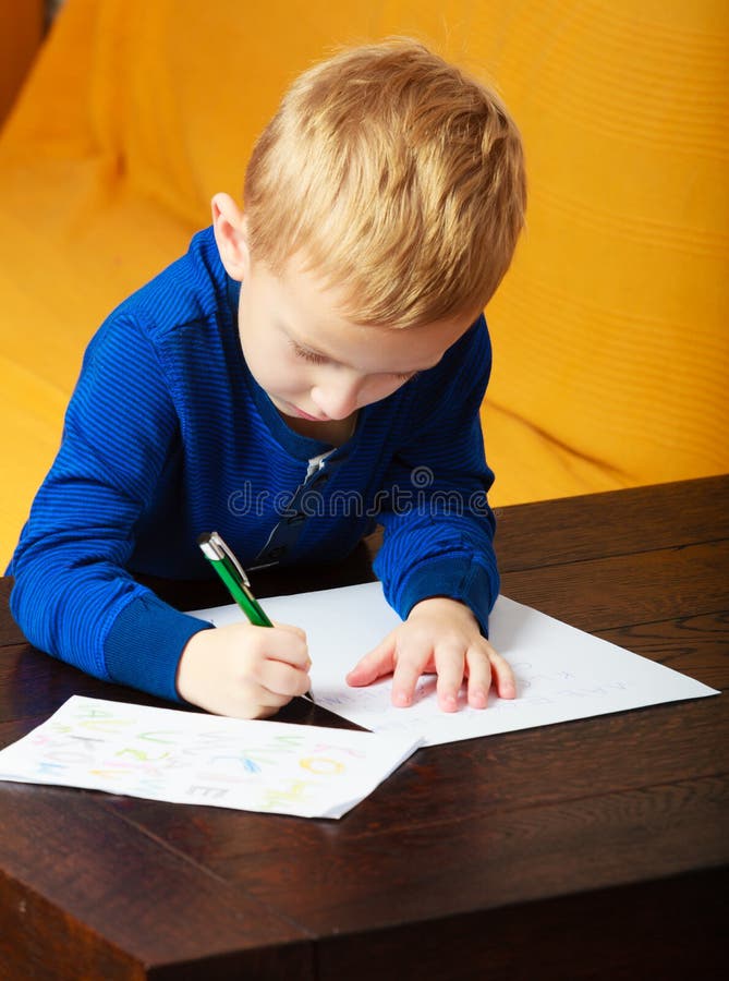 Blond Boy Child Kid with Pen Writing on Piece of Paper. at Home. Stock ...