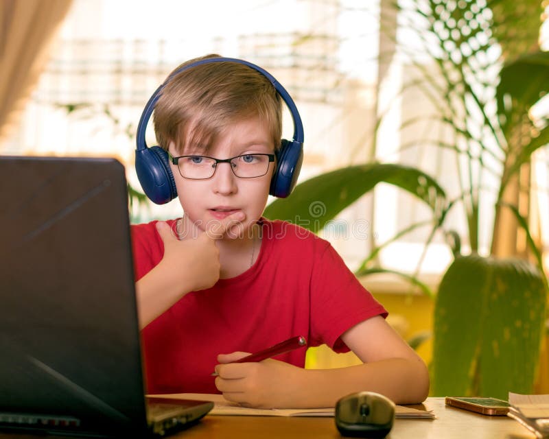 Blond Boy Does Homework at the Table in Headphones Stock Image - Image ...