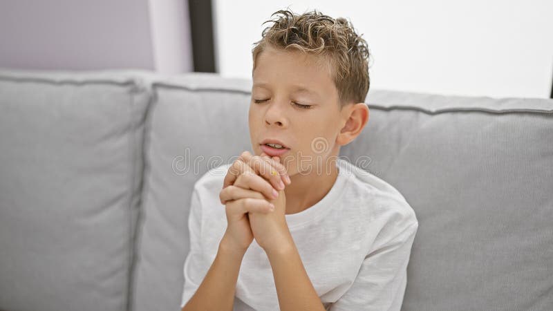 Blond Boy Praying Sitting on Sofa at Home Stock Photo - Image of relax ...