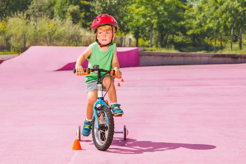 Blond Boy Ride Small Bicycle with Learning Wheels Around Cones Stock ...