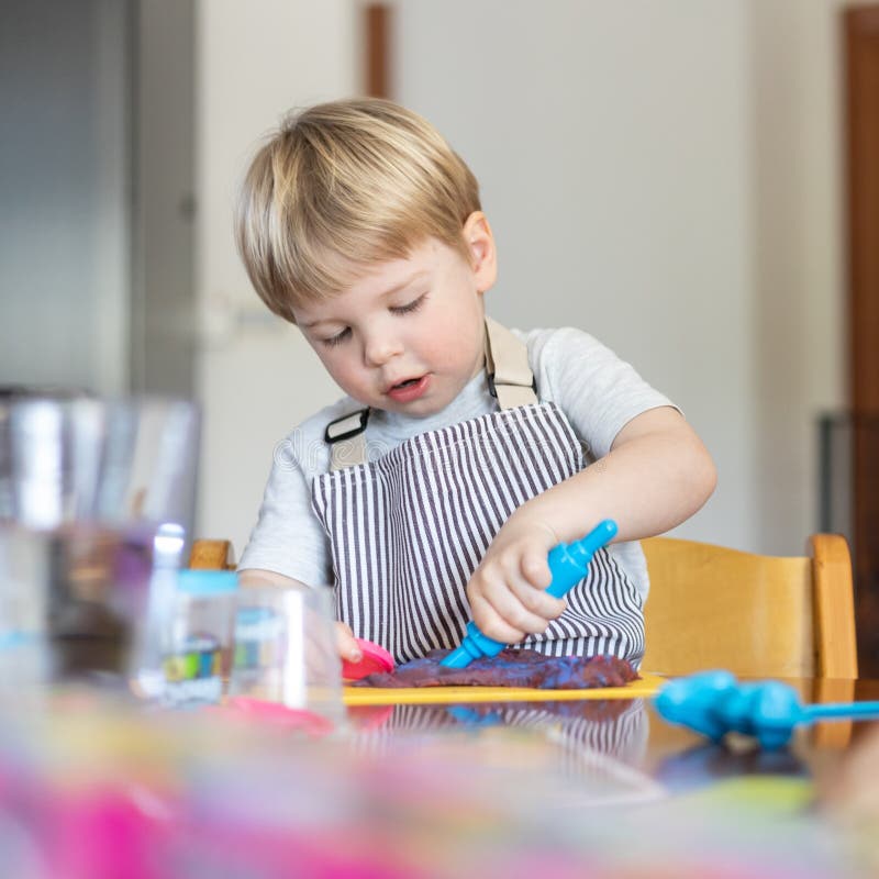 Blond Boy Sculpts from Plasticine at Home at the Table. the Idea and ...