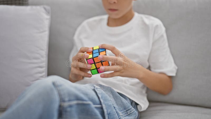 Blond Boy Sitting on Sofa Playing with Rubik Cube at Home Stock Video ...