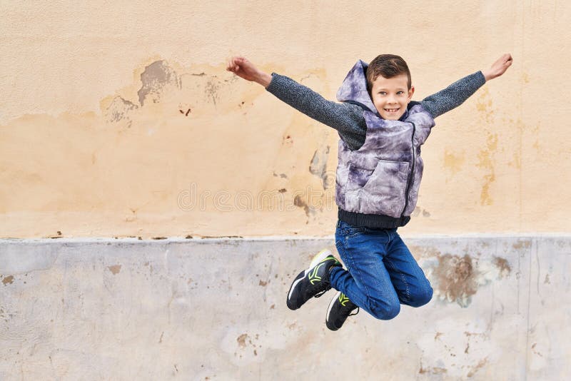 Blond Child Smiling Confident Jumping at Street Stock Image - Image of ...