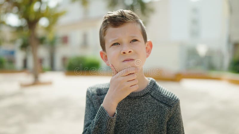 Blond Child Standing with Doubt Expression at Park Stock Video - Video ...