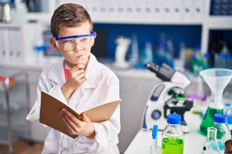 Blond Child Wearing Scientist Uniform Reading Book at Laboratory Stock ...