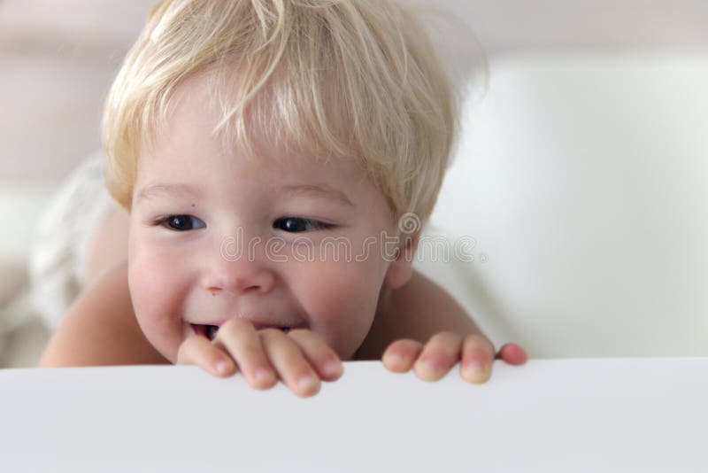 Blond Kid Slyly Looks from Table Stock Photo - Image of white, look ...