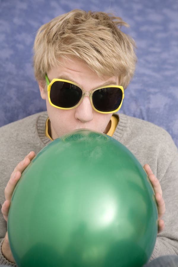 Blond Man Blowing a Green Balloon Stock Image - Image of sunglasses ...