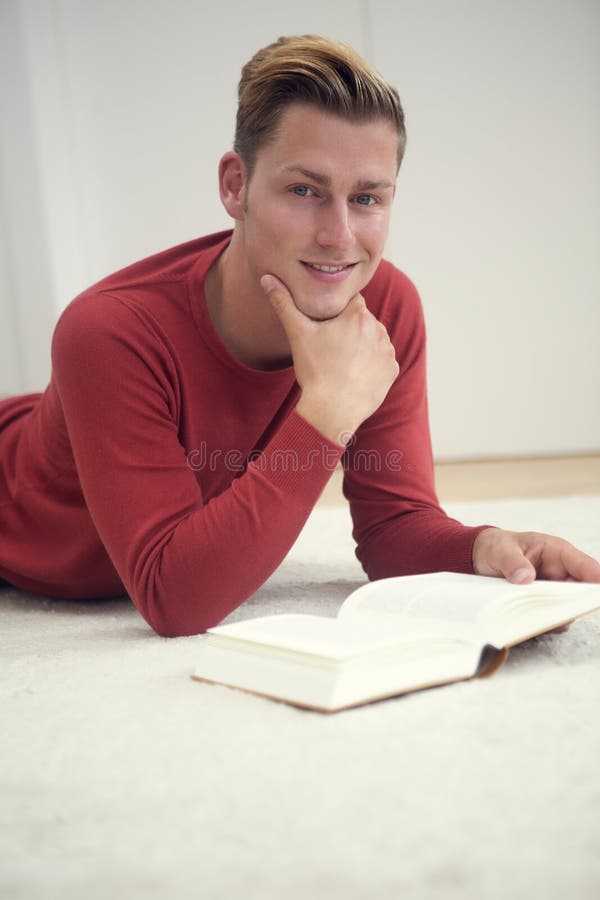 Blond Man Lying on Floor and Reading a Book Stock Image - Image of room ...