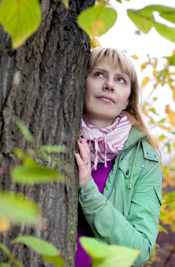 Blond Woman Looking Out from the Tree Stock Photo - Image of blond ...