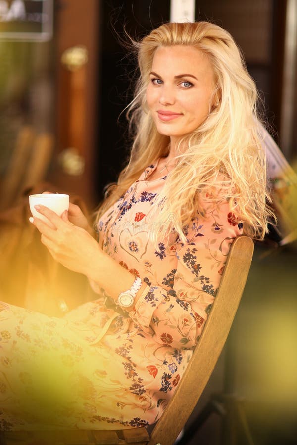 Blond Woman On Lunch Break Sit In Summer Outdoor Cafe With Cup O Stock