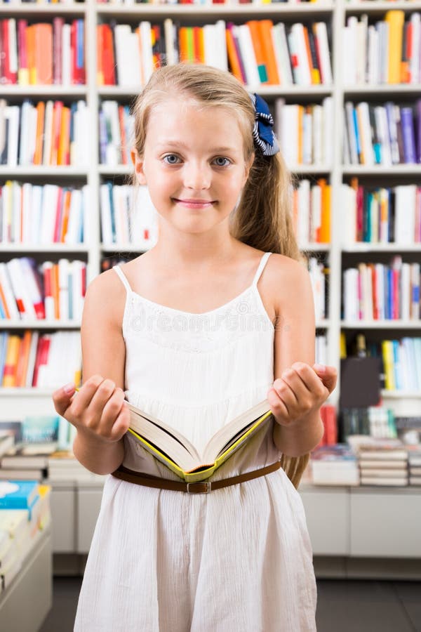 Blonde Girl Chooses a Book in the Library Stock Photo - Image of object ...
