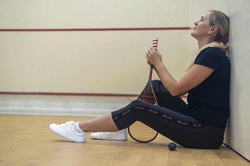 Blonde Girl Sitting on the Floor and Holding a Squash Racket Stock ...