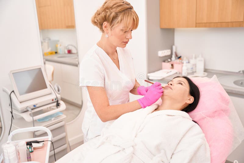Blonde Marks the Lips of a Client before the Procedure Stock Photo ...