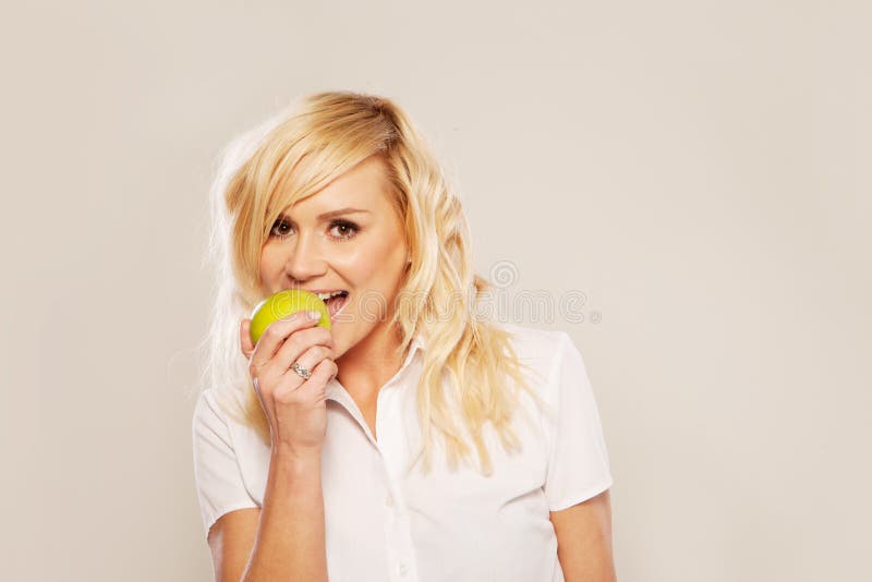 Blonde Woman Biting an Apple Stock Photo - Image of apple, freshness ...