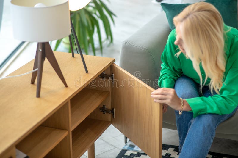 Blonde Woman in a Green Blouse Opening the Drawer Stock Photo - Image ...
