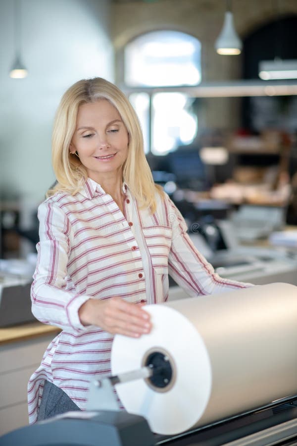 Blonde Woman Standing at Paper Roll Machine, Holding Paper Roll Stock ...